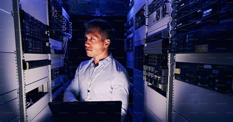 코로케이션 데이터 센터의 네트워크 서버를 모니터링하는 노트북을 사용하는 심각한 It 기술자 사진 Unsplash의 서버 이미지