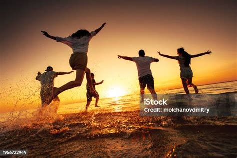 행복한 젊은 친구들이 일몰 해변에서 달리고 점프합니다 우정에 대한 스톡 사진 및 기타 이미지 우정 해변 행복 Istock