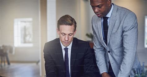 사무실의 책상에서 함께 일하면서 메모와 문서를 검토하는 두 명의 다양한 사업가 사진 Unsplash의 앉아 이미지