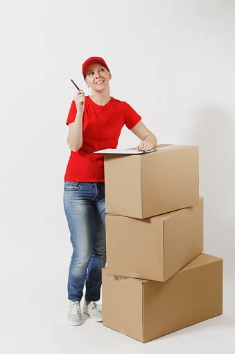 빨간 모자에 배달 여자의 전체 길이 T셔츠는 흰색 배경에 고립 여성 택배 종이 문서 빈 골 판지 상자에 빈 빈 시트와 클립보드를 들고 수신 패키지입니다 가냘픈에 대한 스톡