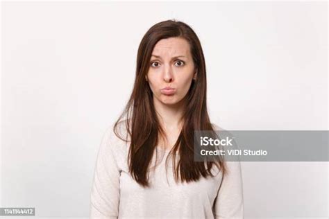 스튜디오에서 흰색 벽 배경에 고립 된 입술을 불고 가벼운 옷에 당황 불쾌 한 기분을 상하게 젊은 여자의 초상화 사람들은 진심으로 감정 라이프 스타일 개념입니다 복사 공간을