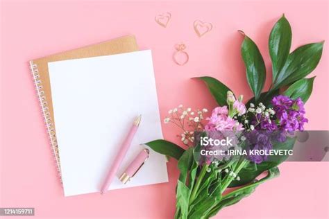 분홍색 배경에 종이 클립 하트와 반지와 꽃다발 나선형 황금 메모장에 빈 흰색 시트 텍스트와 디자인에 대한 개념 낭만적 인 사랑 모형 상단 보기 플랫 레이 0명에 대한 스톡
