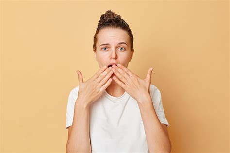 하얀 티셔츠를 입은 충격을 받은 겁에 질린 여자는 머리 보습을 위해 마스크를 사용하여 베이지색 배경 위에 격리된 샴푸 거품으로 머리를 감는다 30 34세에 대한 스톡 사진