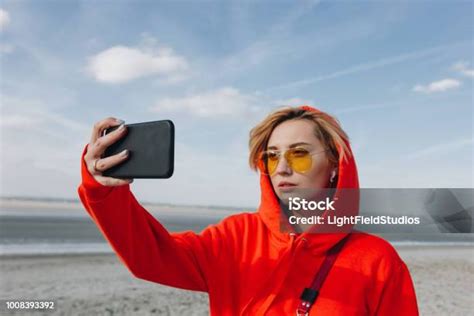프랑스 아름 다운 해변 세인트 마이클스 마운트 스마트폰에 Selfie를 복용 하는 선글라스에 매력적인 여자 관광에 대한 스톡 사진 및 기타 이미지 Istock
