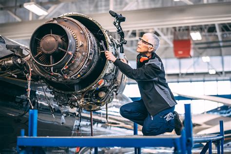 항공기 격납고에서 유지 보수 하는 동안 개인 비행기에 작은 제트 엔진의 일부를 Unscrewing 노인 여성 비행기 정비공 기술자에 대한 스톡 사진 및 기타 이미지 Istock