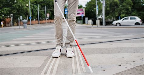 도시의 거리를 가로질러 걷고 있는 흰 지팡이를 짚은 알아볼 수 없는 젊은 장님의 중간 부분 사진 Unsplash의 슬로바키아 이미지