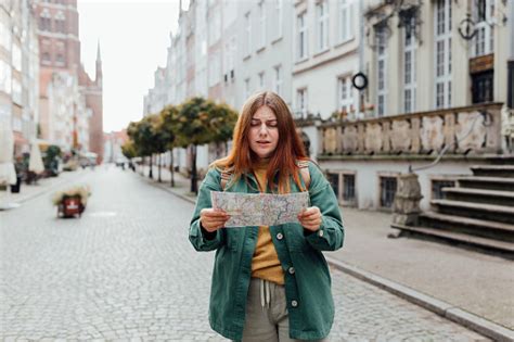 초상화 아름 다운 여자 와 종이 지도 와 도시 거리 통하고 있는 젊은 걱정하는 여성 여행자는 지도를 사용하여 도시에서 길을