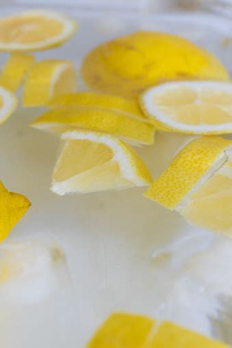 육즙이 많은 레몬 조각은 노란색 배경에 매우 차가운 주전자에 얼음과 물을 넣고 선택적 초점을 맞춥니다 레몬과 얼음이 많이 들어간 레모네이드 0명에 대한 스톡 사진 및 기타