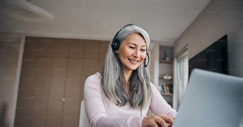 테이블에 앉아 노트북으로 작업하는 동안 헤드셋을 착용한 웃는 여자 사진 Unsplash의 컴퓨터 키보드 이미지