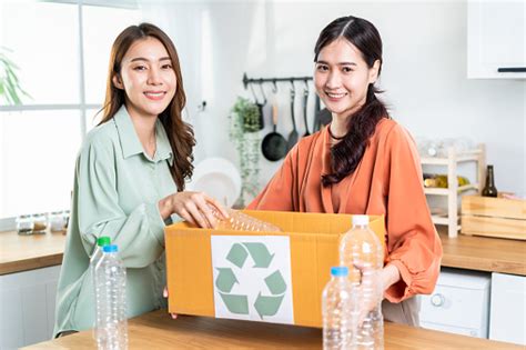추가 재활용을 위해 쓰레기를 분리하는 아시아의 아름다운 여성의 초상화 매력적인 여성은 생태 친화적이고 환경을 절약하고 카메라를 볼 수 있습니다 재활용 상자에 플라스틱 병을