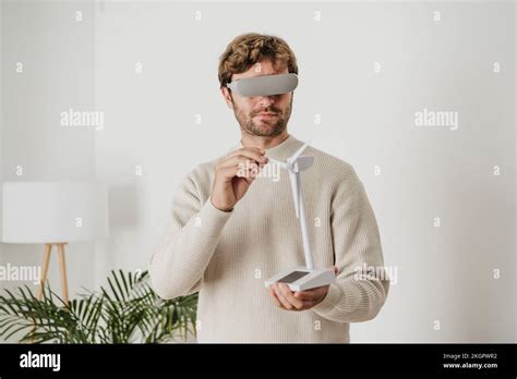 Businessman Examining Wind Turbine Model Through Vr Goggles In Front Of