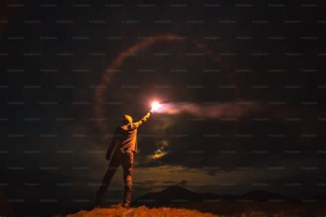 The Man With A Bright Firework Stick Standing On A Mountain Evening