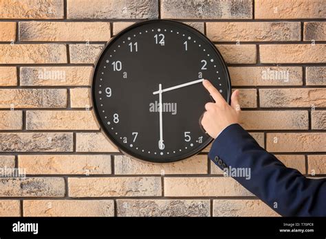 Man Pointing On Clock Against Wall Background Time Management Concept Stock Photo Alamy