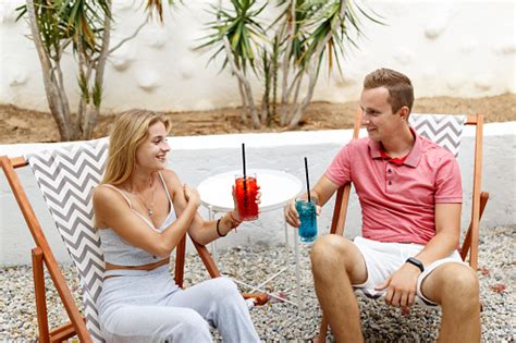 바다 해변이나 카페 장소에서 갑판 의자에 앉아 레모네이드 잔을 가진 행복한 젊은 커플 20 24세에 대한 스톡 사진 및 기타 이미지 20 24세 25 29세 2명