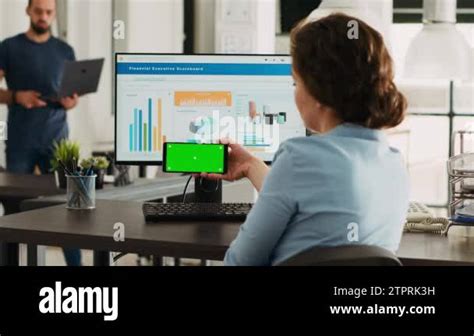 Office Worker Looks At Greenscreen On Smartphone Display App Analyzing