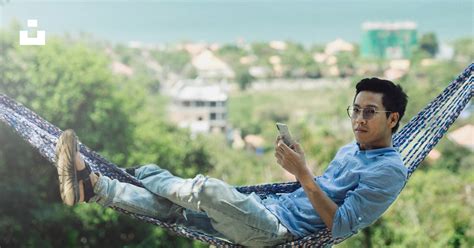 낮 동안 흰색 금속 울타리에 앉아 파란색 폴로 셔츠를 입은 남자 사진 Unsplash의 무료 파랑 이미지