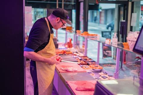 Premium Photo Butcher Sharpening Knife At Butcher Shop Counter