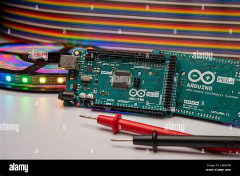 Arduino Mega Front And Back Displayed With LED Strip Multimeter And Jumper Wire Background