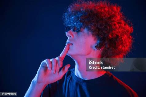 빨간색과 파란색 색상 곱슬머리를 한 청년이 실내에서 네온 불빛으로 조명된다 18 19세에 대한 스톡 사진 및 기타 이미지 18 19세 곱슬 머리 남성 Istock