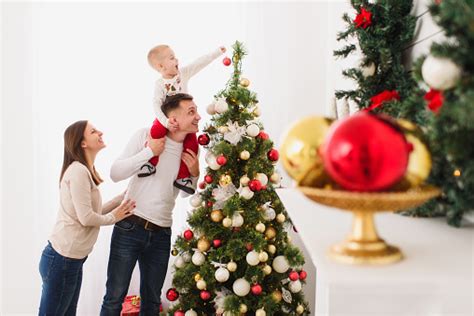 귀여운 작은 아들과 함께 행복 한 젊은 명랑 한 부모 라이트 룸에서 집에서 장난감 공 새 해 트리를 장식 하는 아빠 어깨에 아이 보 크리스마스 좋은 분위기 가족 사랑 휴일