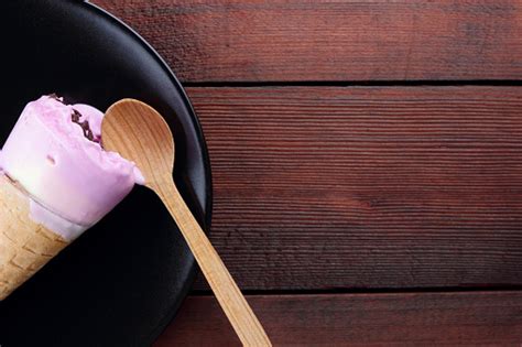 검정 잉크 판에 초콜릿 아이스크림 콘 어두운 나무 배경에 아이스크림입니다 나무 숟가락으로 와플 컵에 차가운 우유 디저트 여름