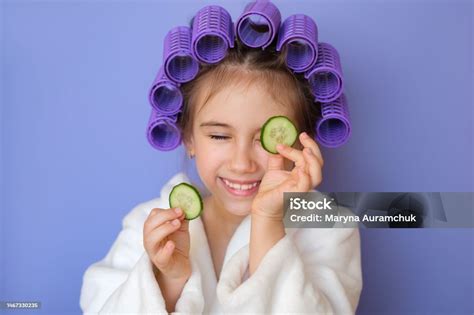 고데기로 감싼 머리를 가진 작은 아가씨가 신선한 오이 조각을 눈에 씌운다 뷰티 스파에 대한 스톡 사진 및 기타 이미지 뷰티 스파 소녀 건강한 식생활 Istock