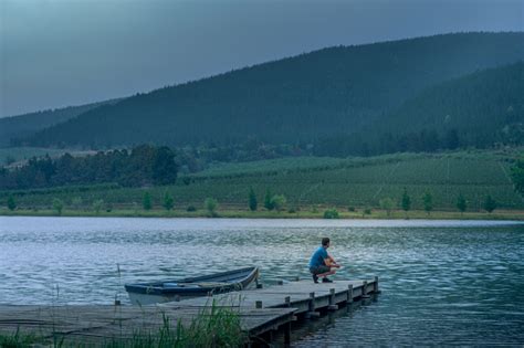 산을 내려다 정박 중인된 노 젓는 보트와 아름 다운 호수에 나무 부두에 무릎을 꿇 고 하는 남자 40 44세에 대한 스톡 사진 및 기타 이미지 Istock