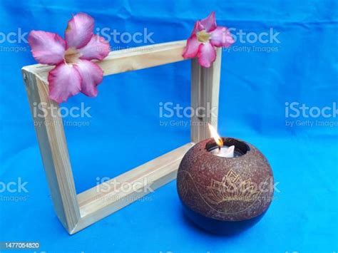 꽃 머리가 있는 그라데이션 파란색 배경의 나무 액자 사각형 상자 아데늄 사막 장미와 촛대 정물 개념이라고 불리는 아름다운 붉은