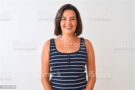 얼굴에 행복하고 시원한 미소와 고립 된 흰색 배경 위에 서 파란색 줄무늬 티셔츠를 입고 젊은 아름다운 여성 운이 좋은 사람 T 셔츠에 대한 스톡 사진 및 기타 이미지