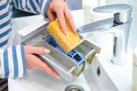 Housewife Hands Cleaning Plastic Container Of Washing Machine Use Sponge And Water At Bathroom