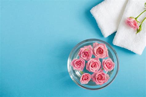유리 그릇에 분홍색 장미가 든 물 파란색 배경에 흰색 수건이 있습니다 공간을 복사합니다 상단 보기 0명에 대한 스톡 사진 및 기타 이미지 Istock