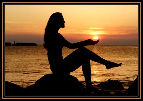 Фото Девушка на море держит солнце на ладонях