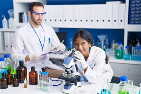 Man And Woman Scientists Using Microscope Working At Laboratory Stock Photo Image Of