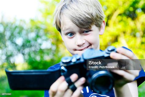 뒷면 카메라와 계몽 오픈 보고 슬픈 소년 영화 내부 파괴 야외 촬영 오래 된 카메라와 작은 금발 아이 보 아이 빈티지 레트로 필름 카메라를 사용 하 여 사진을 복용 귀여운에