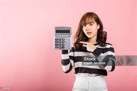 계산기와 손가락 포인트 장치를 들고 미소 짓는 여자 초상화 흥분 행복한 아시아 여성 스튜디오 촬영 분홍색 배경에 고립 계좌 및