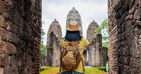 아시아 관광 여성은 태국 수코타이 Sukhothai에서 태국 건축물의 고대 탑 사원 사진을 찍습니다 캐주얼 태국 옷감 스타일의 여성 여행자 방문 도시 개념 사진