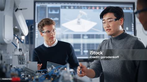 남학생이 동급생과 흑인 교사와 함께 프로젝트를 진행하는 동안 태블릿을 들고 몸짓을 하고 있다 수업 중 현대 기술을 분석하는 사람들 과학 및 개발 개념 일본 민족에 대한 스톡