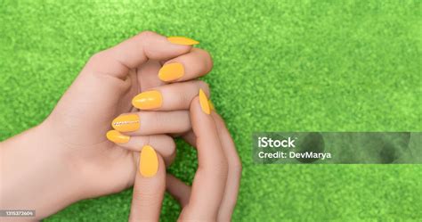 노란 네일 디자인의 여성 손 노란색 매니큐어 매니큐어 여자는 녹색 반짝이 배경에 손을 공간을 복사합니다 네일 살롱에 대한 스톡 사진 및 기타 이미지 Istock