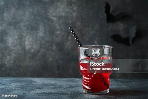 할로윈 피 묻은 칵테일 할로윈을 위한 피 묻은 빨간 칵테일 유리 잔과 어두운 배경에 병 형태의 두개골 사탕 눈 박쥐 거미와 할로윈 파티 Dia De Los Muertos