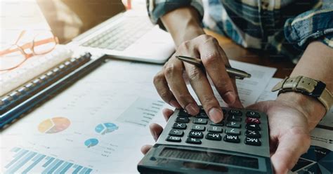 계산기로 재무 및 분석 비즈니스 문서를 작성하고 사무실에서 안경을 들고 비용을 계산하는 남자 회계 개념 사진 Unsplash의 계산기 이미지