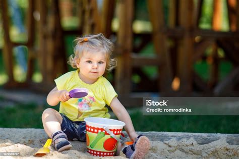 야외 놀이터에서 모래에서 노는 행복한 유아 소녀 화창한 따뜻한 여름 화창한 날에 즐거운 시간을 보내는 아기 모래 장난감과 화려한 패션 옷을 입은 활동적인 아이 건강한 생활