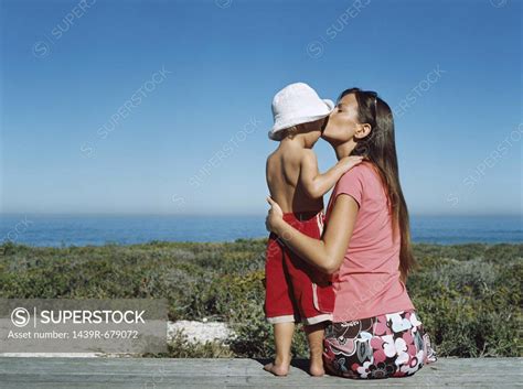 Mother Kissing Her Son On The Forehead SuperStock