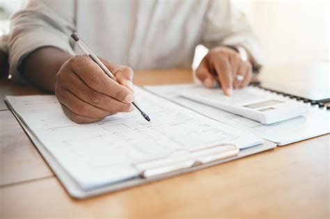 계산기 재정 및 예산 지불 및 저축 계산을 위해 사람의 손으로 쓰기 세금 감사 및 은행 비용 청구서 및 송장 서류에 대한