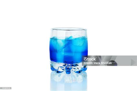 얼음 큐브와 흰색 배경 에 반사 블루 알코올 음료 한 잔 고립 된 클로즈업 블루 라군 칵테일 압생트 샷 삼부카 블루 크립라 카오
