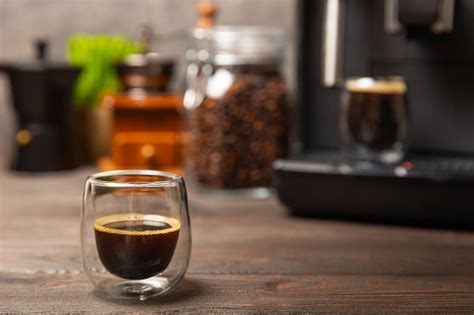 식탁에 컵이 있는 현대적인 커피 머신 커피 하우스 주방에 컵이 있는 현대적인 에스프레소 커피 머신 향기로운 뜨거운 음료의 준비 텍스트를 위한 위치입니다 복사 공간 0명에