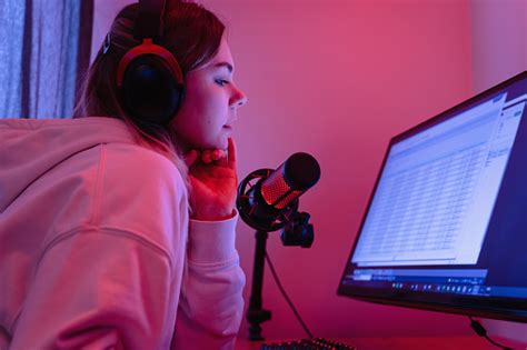 네온 조명이있는 방에서 온라인 팟 캐스트 중에 콘덴서 마이크를 사용하는 여성 블로거 20 24세에 대한 스톡 사진 및 기타 이미지 20 24세 30 34세 Brand