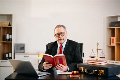 사무실 책상에서 의사봉과 법률 서적이 있는 노트북으로 작업하는 선임 백인 변호사 사법부 법률 변호사 및 법정 개념 65 69세에 대한 스톡 사진 및 기타 이미지 Istock