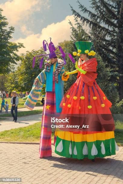카자흐스탄 국립 의상을 입은 남자와 소녀가 죽마에 서서 공원의 휴일에 마을 사람들을 맞이합니다 2명에 대한 스톡 사진 및 기타 이미지 Istock