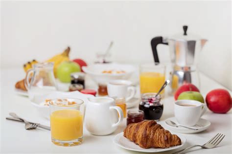 아침 식사 시간 크루아상 오렌지 주스 잼 및 꿀 크림 또는 우유와 커피 과일바나나 빨간색과 녹색 사과 사 워 크림 견과류 및 말린 살구와 함께 리 코타 건조 식품에 대한