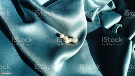 흰색 구슬은 파란색 실크 패브릭에 놓여 있습니다 커튼에 보석 부드러운 표면에 진주 향의 쉬머와 가벼운 주석의 아름다운 조합 원단의 주름과 파도 0명에 대한 스톡 사진 및